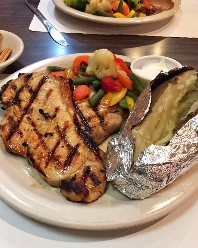 Perfectly grilled protein paired with vibrant vegetables and a foil-wrapped potato – proof that The Country Way's culinary skills extend well beyond breakfast hours.