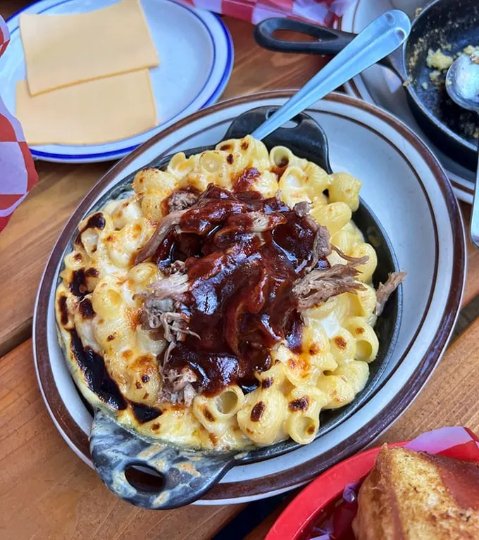 Mac and cheese nirvana achieved! Pulled pork crowns this bubbling cauldron of cheese like royalty atop a golden throne.