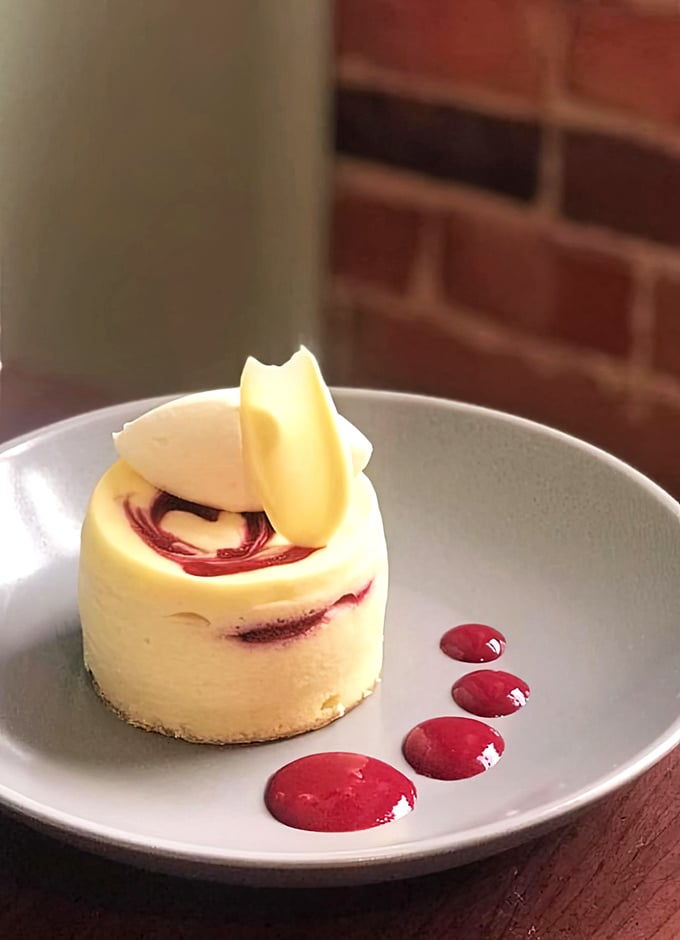 This raspberry-swirled cheesecake isn't just dessert—it's edible architecture with a perfect balance of tangy and sweet that makes taste buds stand at attention.