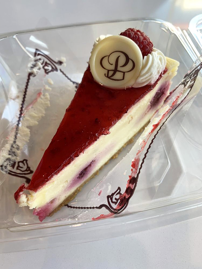 This raspberry cheesecake isn't just dessert—it's edible artwork. The perfect balance of creamy decadence and berry brightness crowned with Porto's signature medallion.