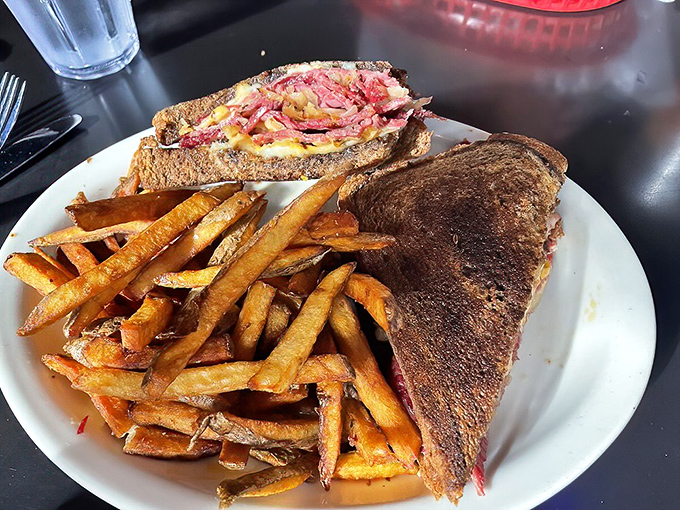 The legendary Reuben arrives like a work of art—perfectly grilled rye bread barely containing a mountain of corned beef, while those hand-cut fries demand equal attention.