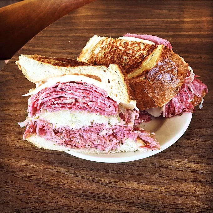 Behold the Reuben in its natural habitat—a mountain of corned beef that requires jaw exercises just to contemplate.