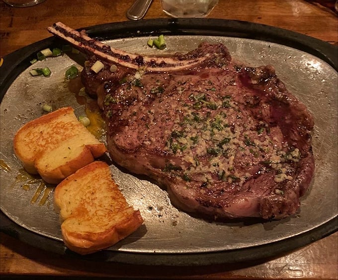 Behold the ribeye in its natural habitat—a sizzling metal plate. That garlic butter pooling around the edges isn't just delicious; it's performing a sacred duty.