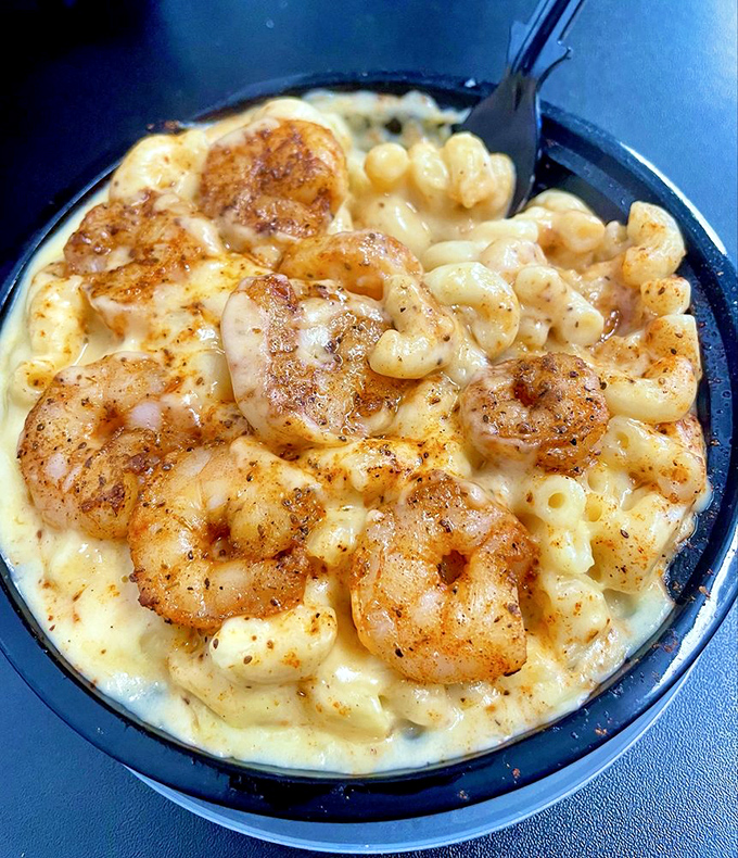 Plump, perfectly seasoned shrimp nestled in a sea of creamy mac and cheese—a combination that makes seafood skeptics reconsider their life choices.