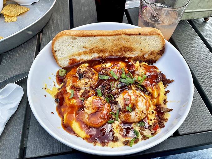 Shrimp and grits that would make a Southerner weep with joy—plump crustaceans nestled on creamy cornmeal heaven with a slice of crusty bread for sopping.