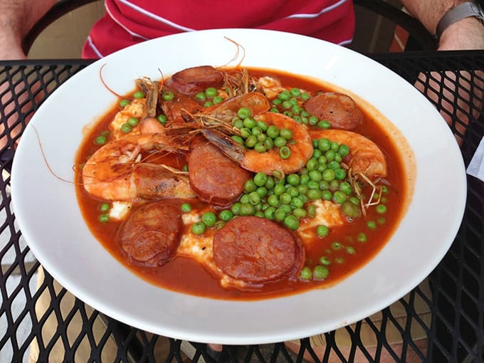 This isn't just shrimp and grits—it's a Southern hug in a bowl. Plump shrimp and spicy sausage swimming in tomato broth with bright green peas for color.