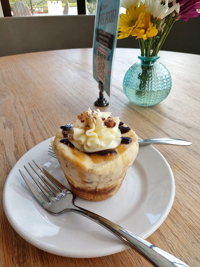 This isn't just cheesecake—it's a tiny tower of temptation topped with whipped cream and what appears to be caramel drizzle. Resistance is futile.