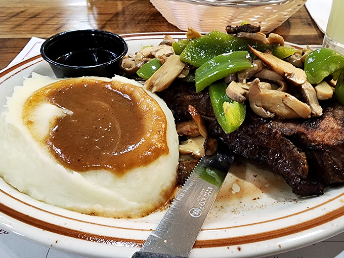 Mashed potatoes swimming in gravy alongside perfectly seared steak and fresh vegetables. This plate doesn't need Instagram filters—it's the real deal.