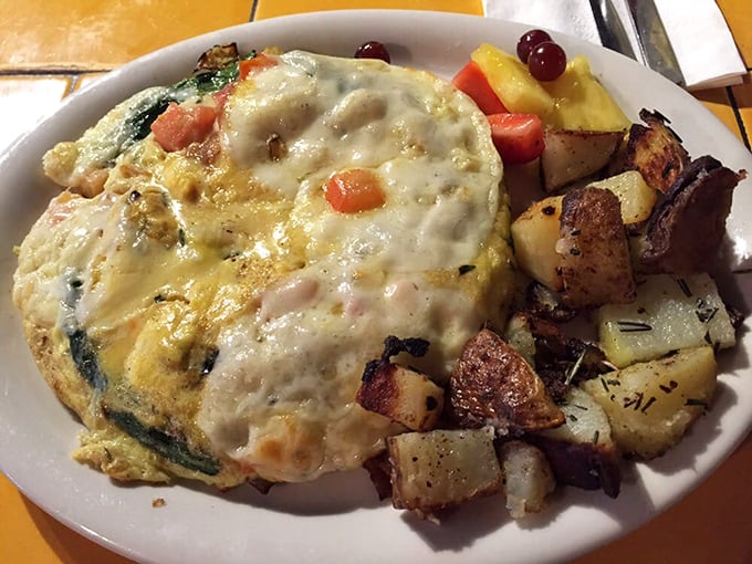 This frittata doesn't just arrive at your table—it makes an entrance. Melted cheese blankets perfectly cooked eggs and colorful vegetables with home fries standing guard.