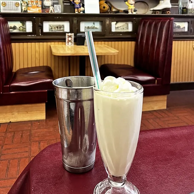 That's not just a milkshake—it's a frothy monument to dairy perfection, served with the metal mixing cup for that crucial extra sip.