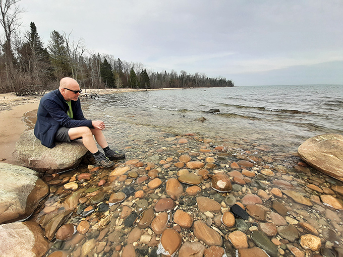 Contemplation rocks! A moment of quiet reflection by Lake Huron's edge, where colorful stones create nature's most perfect meditation spot.