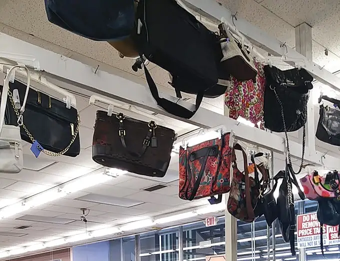 Handbags dangle from the ceiling like fashionable stalactites, each one holding secrets of previous adventures and waiting to start new ones.