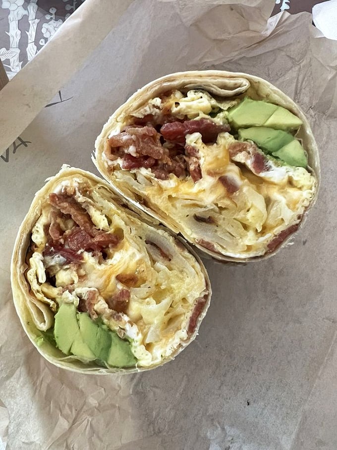 Morning salvation wrapped in a tortilla. This breakfast burrito cradles eggs, bacon, and avocado in perfect harmony—like a lullaby for your hunger pangs.