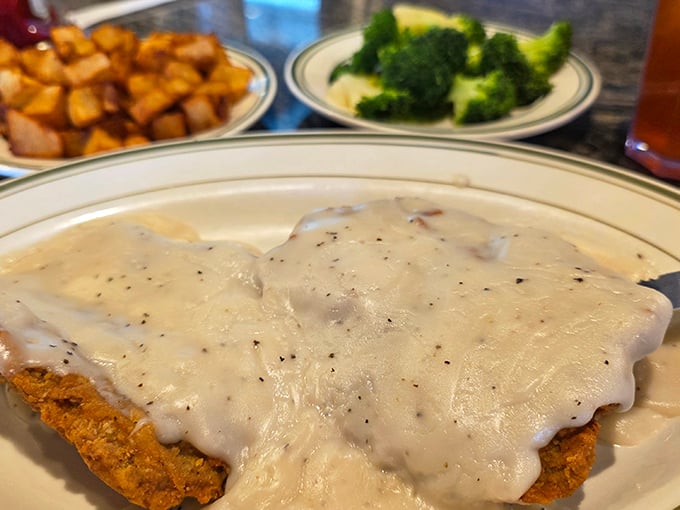 This isn't just country fried steak – it's a golden-breaded masterpiece swimming in peppery gravy that would make any Southern grandmother nod in approval.