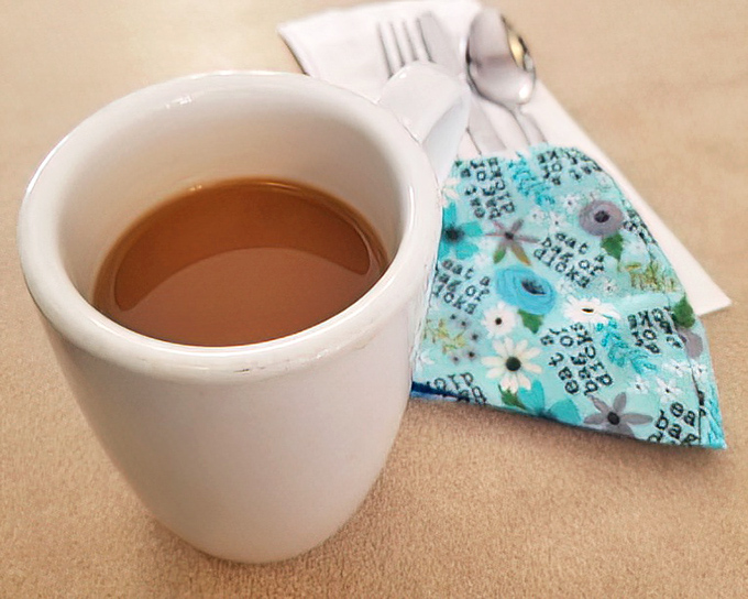 That sturdy white mug holds liquid motivation—honest diner coffee that doesn't need fancy names or artistic foam to get the job done.