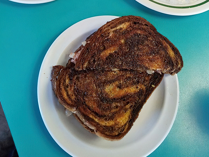 The Reuben arrives like a work of art – marble rye toasted to perfection, with corned beef peeking out as if to say "You made the right choice."