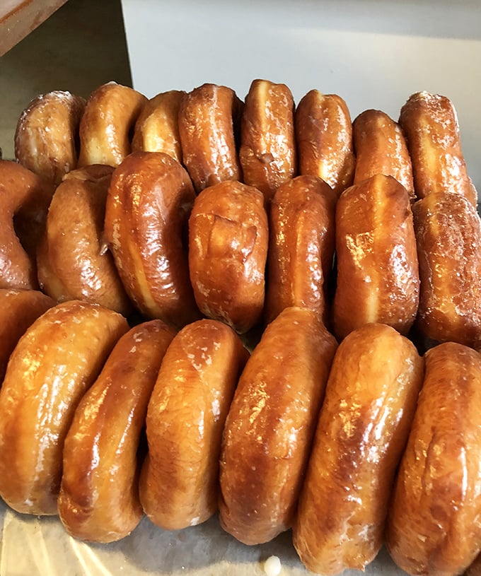 Golden-brown donuts lined up like edible soldiers, ready to sacrifice themselves for your breakfast happiness. Resistance is futile.