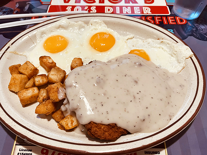 Behold: the Southern Style Chicken Fried Steak in its natural habitat. That pepper-flecked gravy cascading over crispy breading isn't just breakfast—it's performance art with home fries.