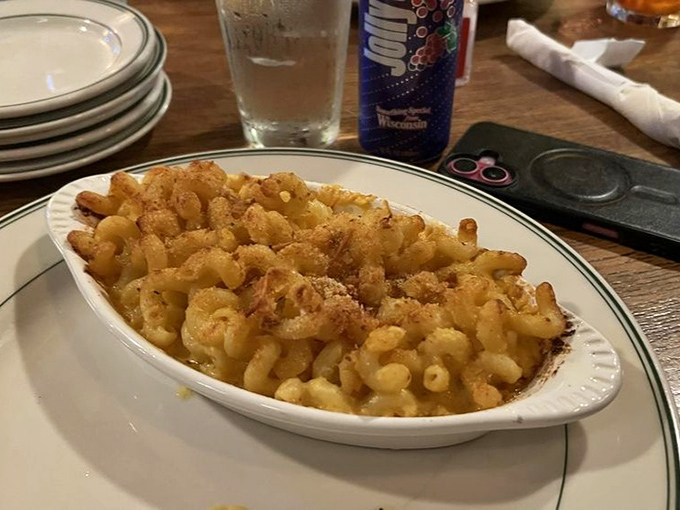 Mac and cheese perfection in its natural habitat – a simple oval dish that transforms humble ingredients into the comfort food equivalent of a warm hug.