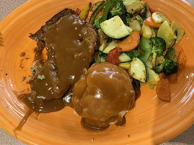 This meatloaf doesn't just sit on the plate – it commands attention with its rich gravy cascading down the sides like a savory waterfall of happiness.
