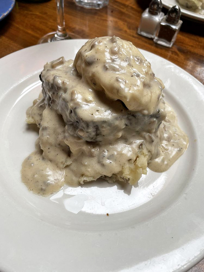 This isn't your grandmother's meatloaf—it's a towering monument to comfort food elevated to art form, smothered in mushroom gravy.