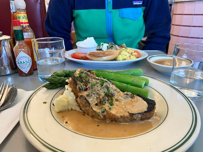 This isn't just meatloaf—it's a savory monument to comfort, bathed in rich gravy and flanked by asparagus soldiers standing at attention.