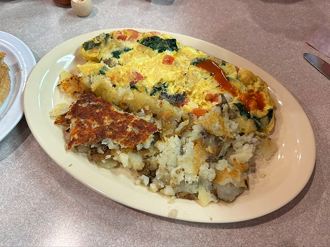 Behold the veggie omelet in its golden glory—where eggs meet vegetables in a relationship so perfect it should have its own reality show.