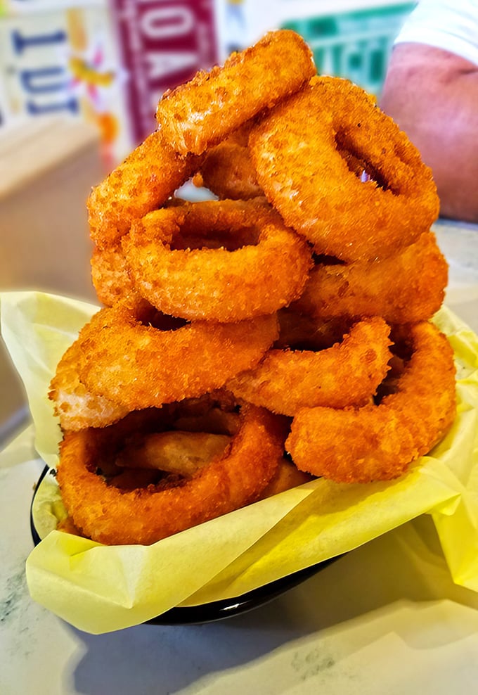 Golden onion rings stacked like edible architecture – crispy perfection that makes waiting absolutely worthwhile.