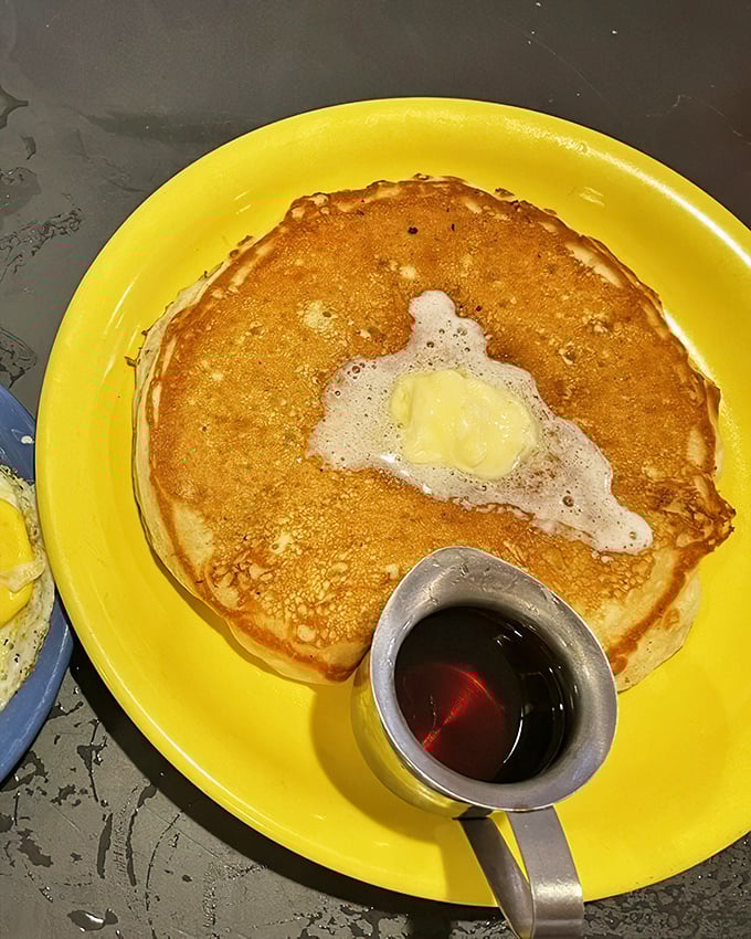 Golden perfection on a sunshine-yellow plate. This pancake doesn't just satisfy hunger—it repairs your very soul, one buttery bite at a time.