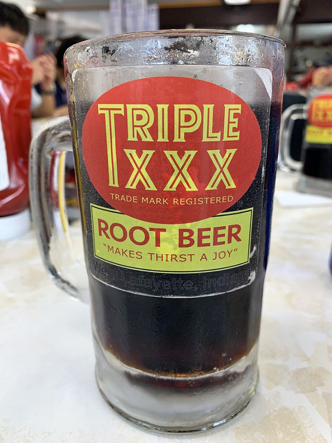 Liquid joy in a frosty mug! Triple XXX's signature root beer—with its perfect balance of vanilla, spice, and fizz—makes "thirst a joy" indeed, as the vintage logo promises.
