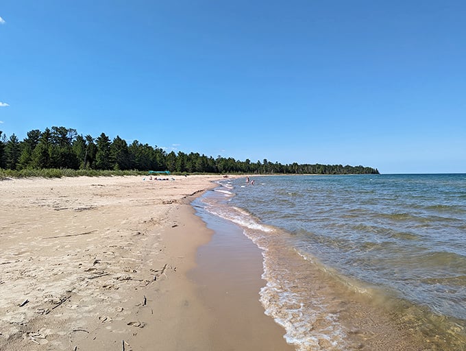 Negwegon's pristine shoreline stretches into the distance, the kind of beach that makes you whisper "wow" even when no one's listening.