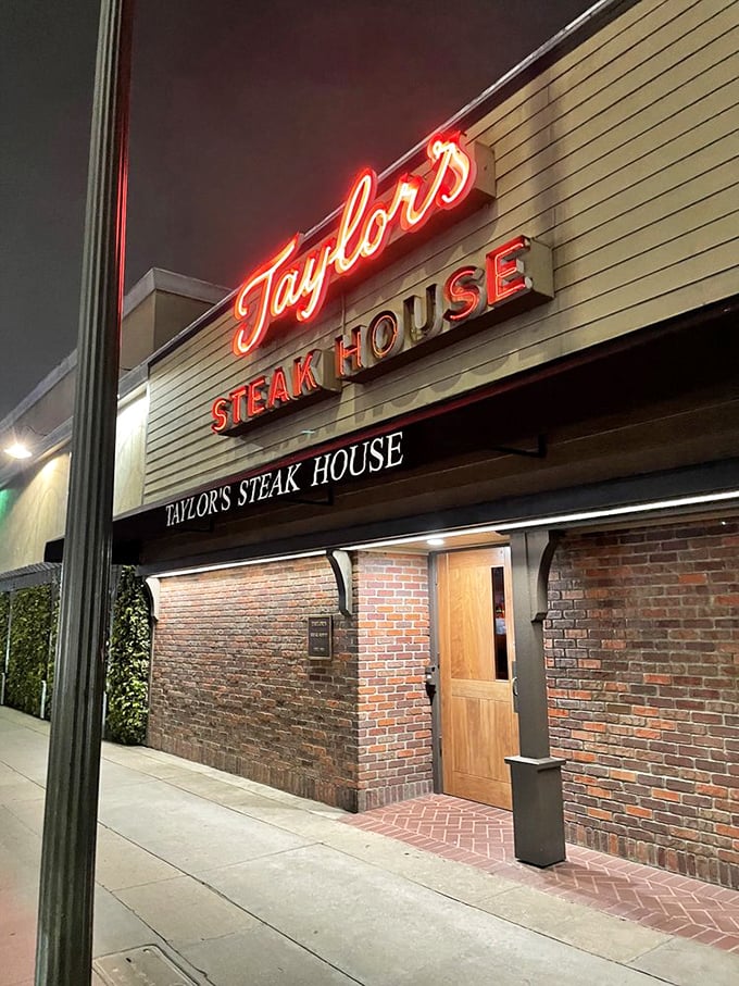 Taylor's red neon glow against brick walls – a steakhouse beacon that's been calling carnivores home for generations.