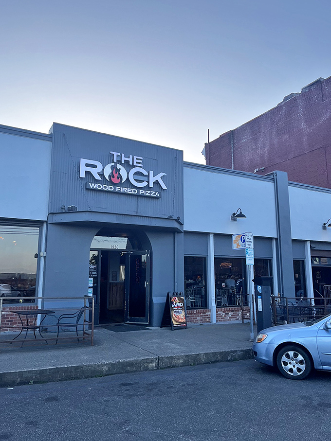 The Rock's industrial-cool exterior gives zero hints about the pizza party happening inside—like finding a concert venue that happens to serve incredible pies.