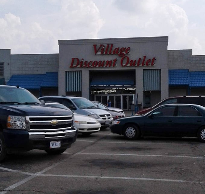 The white and blue facade of Village Discount Outlet – where wallet-friendly adventures begin daily.