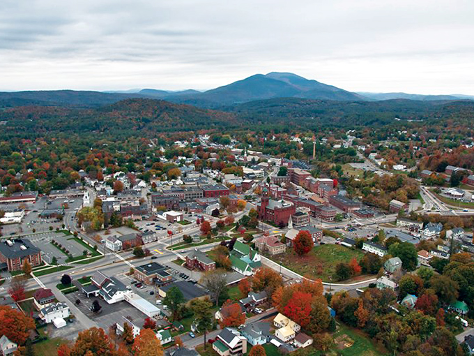 Fall foliage surrounds Claremont like nature's confetti celebration. From above, you can see how the city nestles perfectly between mountains and river.