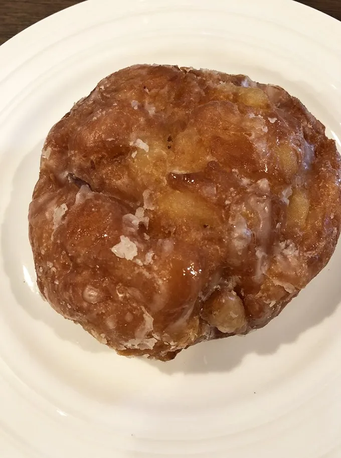 The apple fritter: nature's way of saying "You deserve this." A craggy landscape of cinnamon-spiced apple chunks and crispy edges worth every calorie.