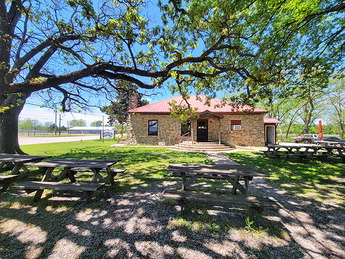 Under shade trees and blue skies, this stone building offers respite from the Oklahoma heat. Simple pleasures in rustic surroundings.