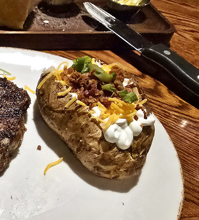 The loaded baked potato isn't just a side dish—it's practically its own food group, complete with the four essential nutrients: cheese, bacon, sour cream, and butter.