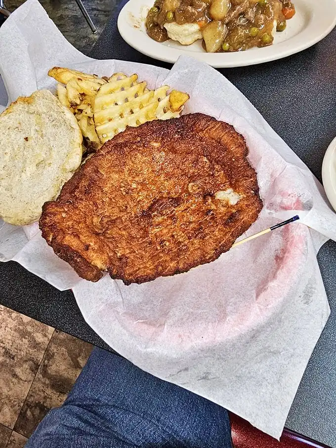 The breaded tenderloin – an Indiana classic that hangs over the plate like a crispy golden frisbee. Sandwich-to-bun ratio: gloriously absurd.