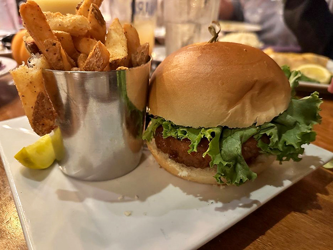 This isn't just a burger—it's a masterclass in comfort food architecture, with perfectly seasoned fries standing at attention in their metal cup.