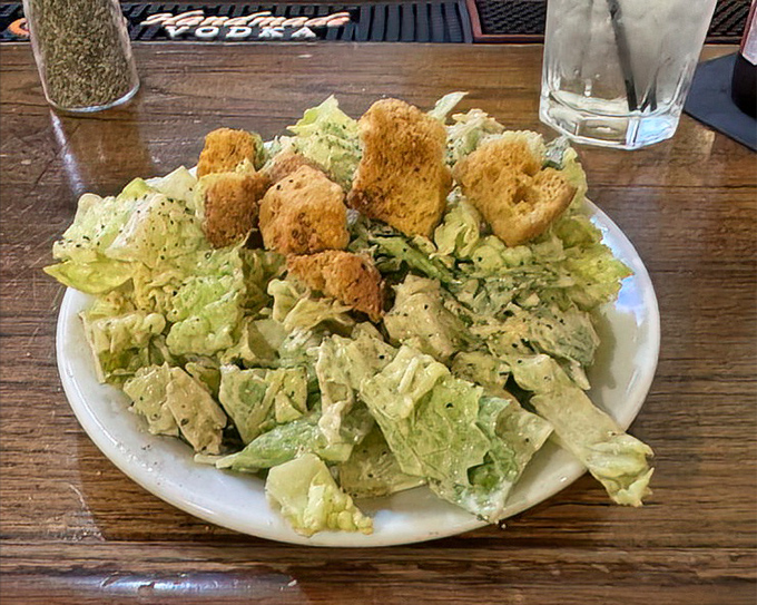 Even the Caesar salad knows its role here—a crisp, refreshing prelude to the main event, not trying to steal the spotlight.