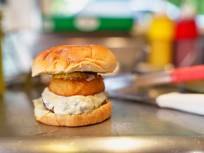 This isn't just a burger – it's architecture. The onion ring crown adds both nobility and that perfect crunch factor.