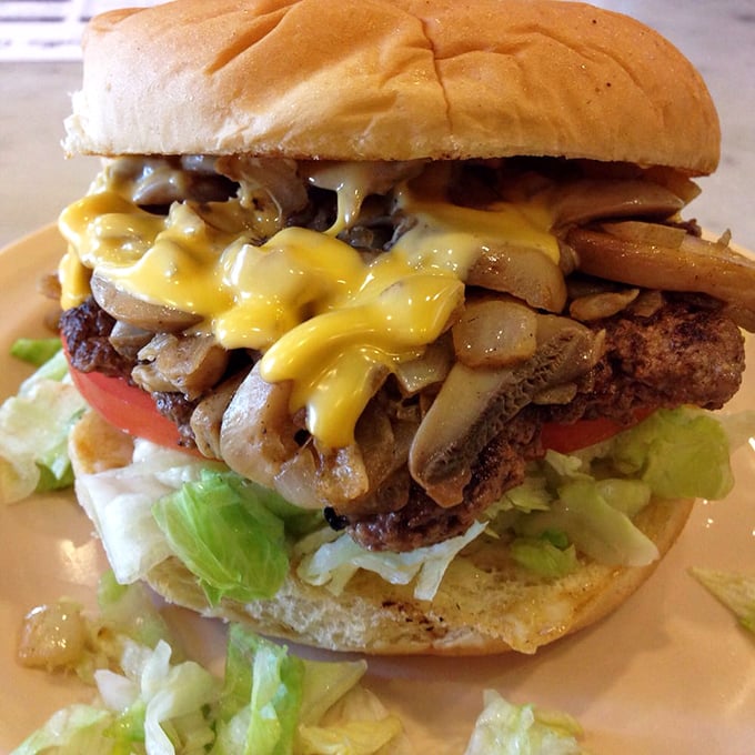 Mushroom and cheese cascade like delicious lava over this burger masterpiece—proof that sometimes more is exactly the right amount.