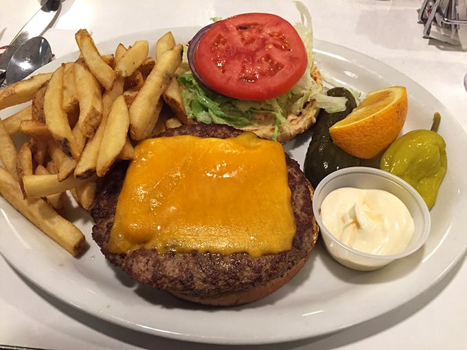 The cheeseburger arrives like a beautiful, edible monument to simplicity – perfectly melted cheese cascading down a juicy patty with crispy fries standing guard.