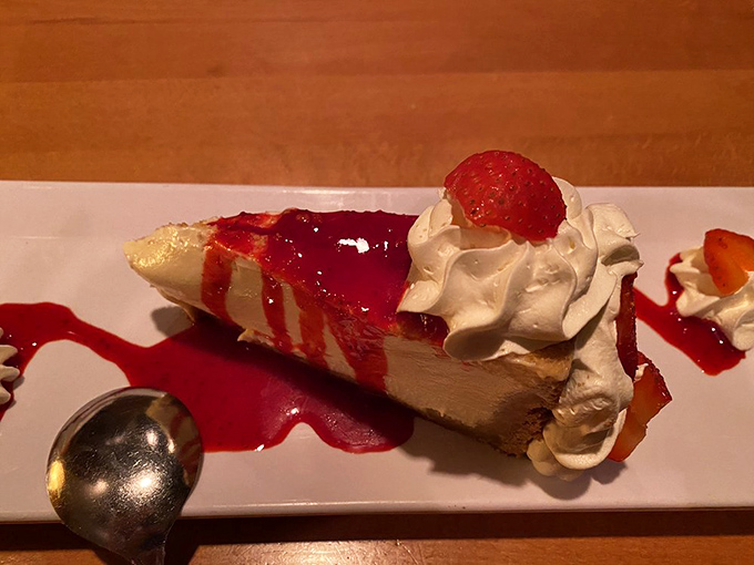 Cheesecake draped in berry sauce and crowned with whipped cream. This slice isn't just dessert—it's the grand finale your taste buds have been rehearsing for all evening.