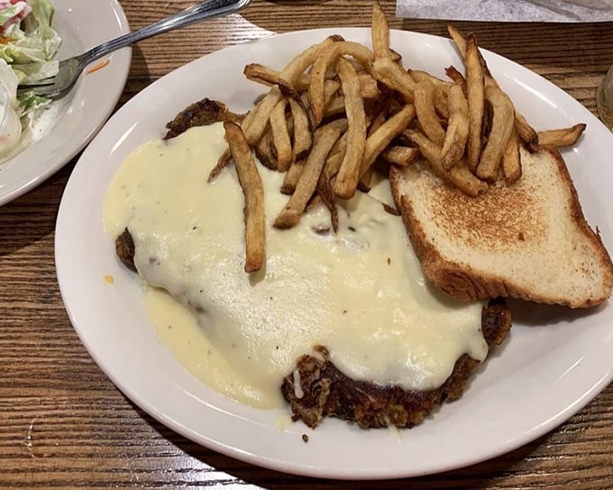 Chicken fried steak smothered in creamy gravy with golden fries—the kind of plate that makes diets spontaneously combust upon arrival.