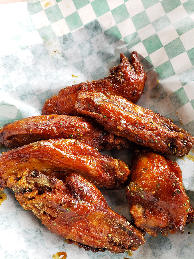 These glistening wings aren't just cooked—they're transformed through smoke and fire into the kind of food that makes conversation impossible.
