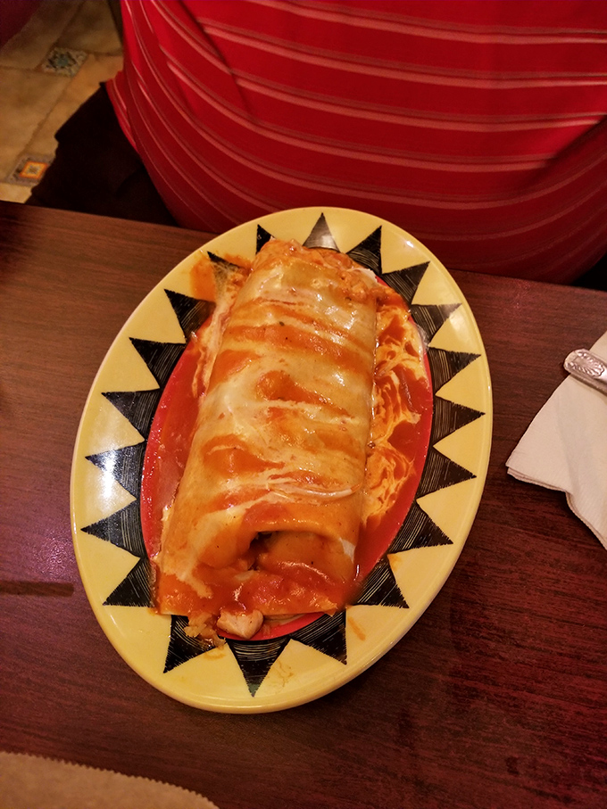 Behold the chicken burrito in its natural habitat – swimming in sauce, melted cheese creating that Instagram-worthy cheese pull moment.