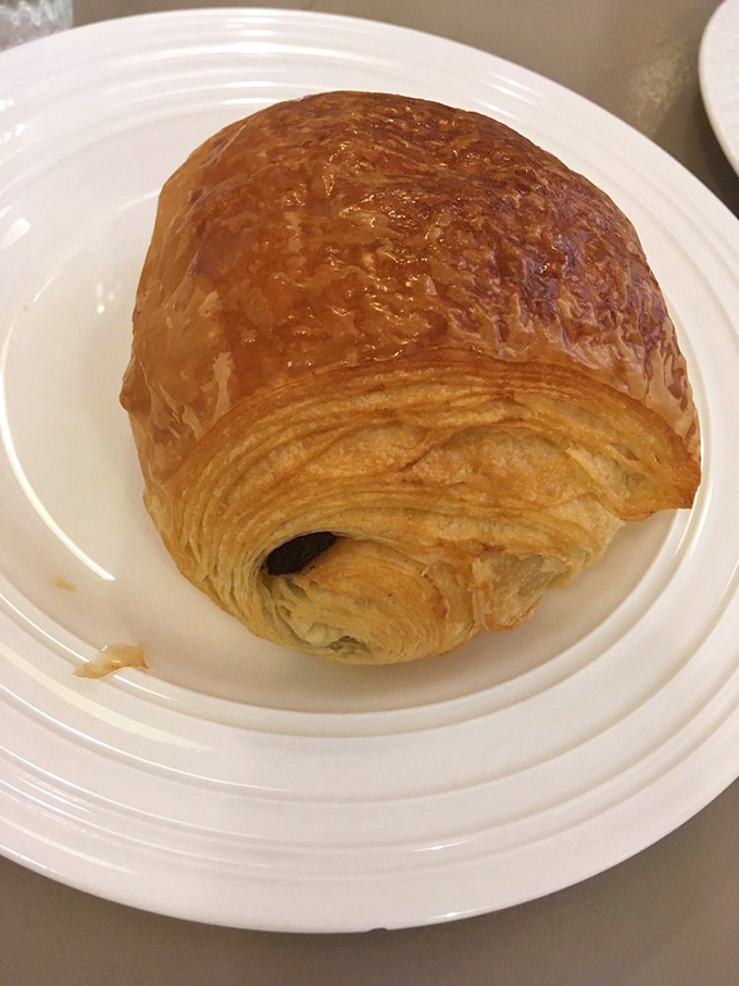 The chocolate croissant's burnished exterior hides dark chocolate ribbons within—proof that the best presents come in flaky packages.