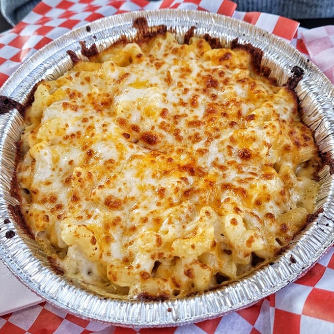 The classic mac and cheese—bronzed to perfection, bubbling with promise. This isn't food; it's a warm hug in an aluminum pan.